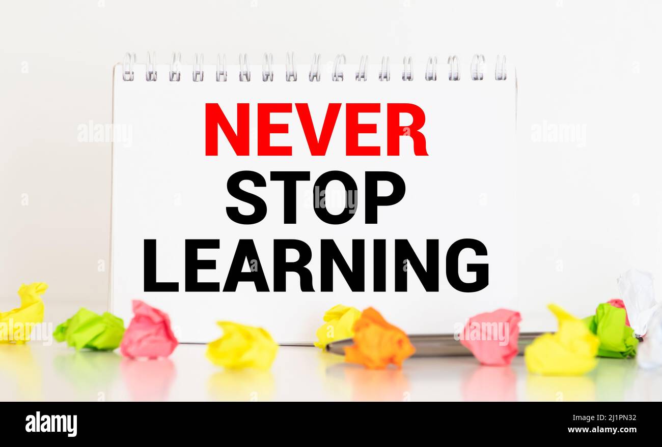 Never Stop Learning, handwriting quotation on notebook Stock Photo - Alamy