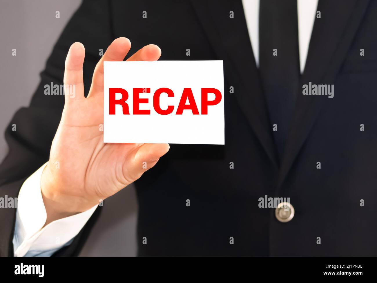RECAP word on white card paper sheet on in hands of a businessman ...