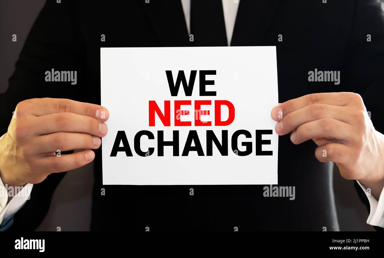man holding a banner of 'We Need A Change' Stock Photo - Alamy