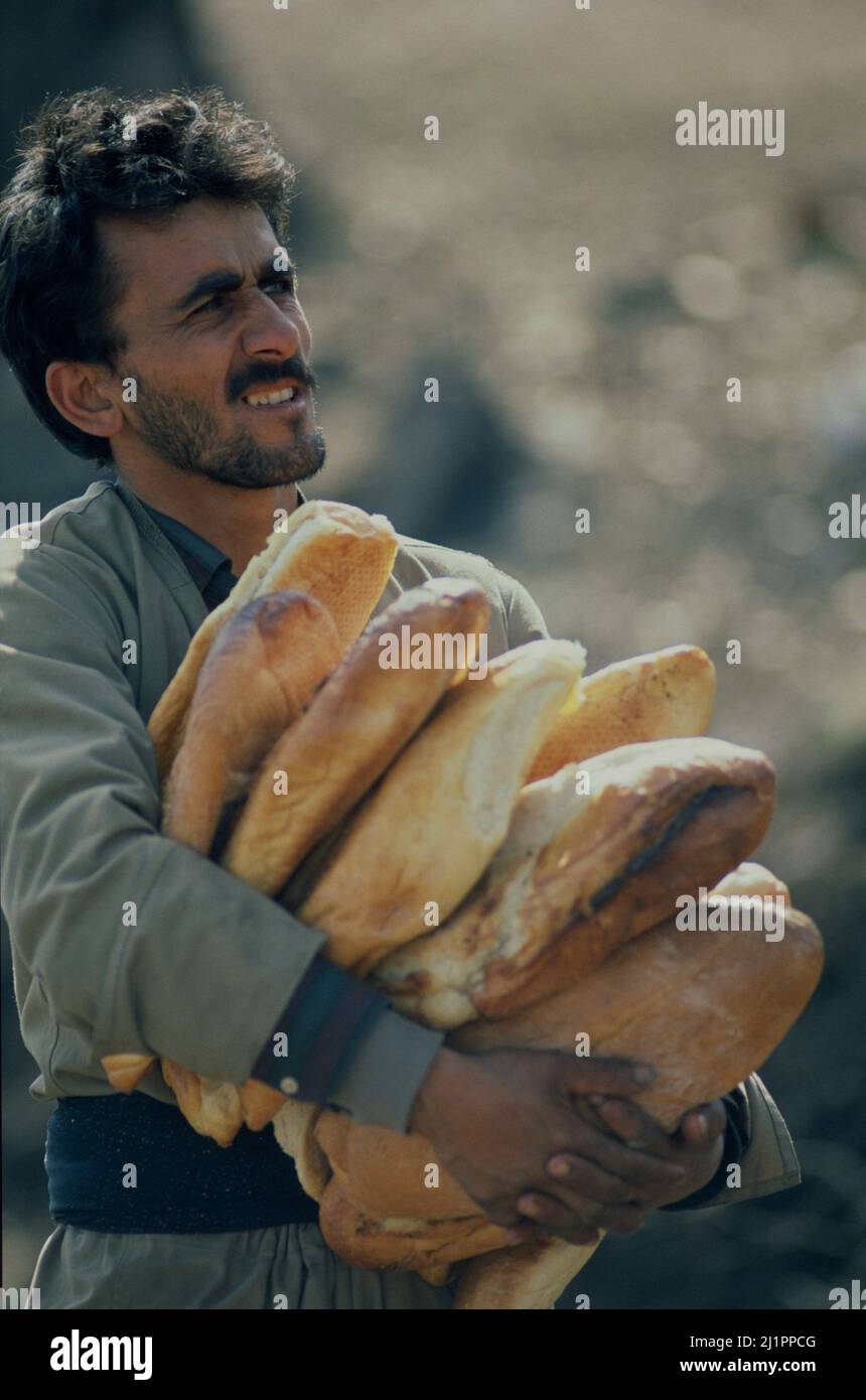 Kurdish Refugee carrys bread as it's distributed in the Isik Veren ...