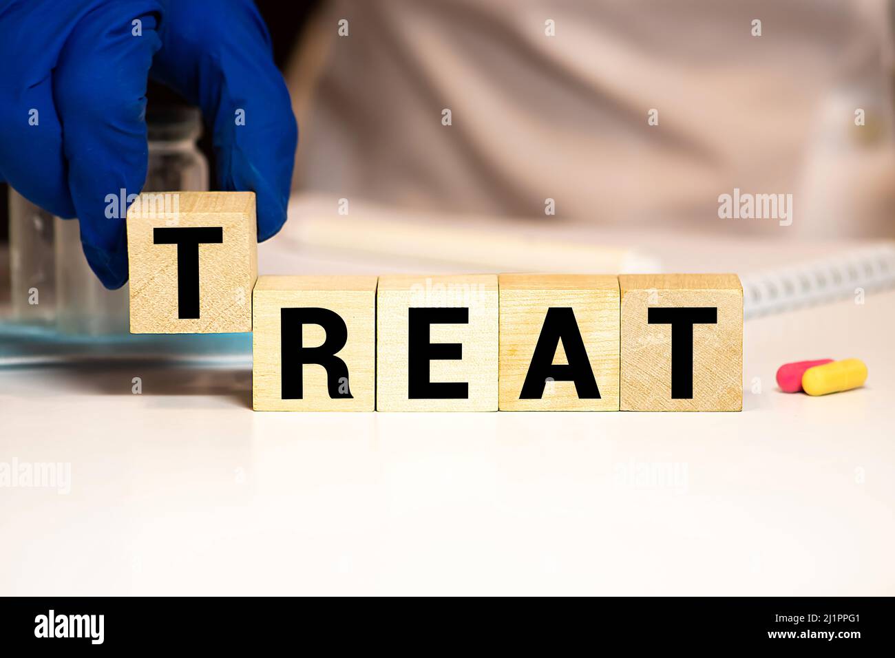 treat - word from wooden blocks with letters holding by a doctor's ...