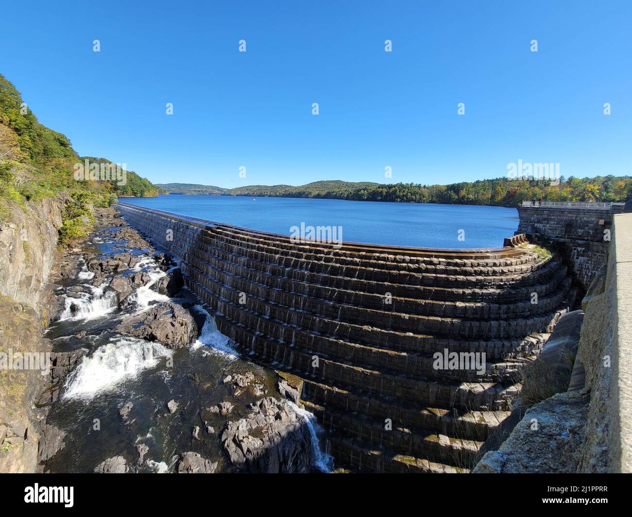A beautiful landscape of a large dam under the clear blue sky at Croton ...