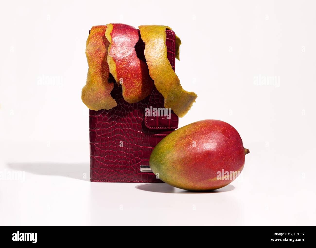 Red purse and mango fruit waste on white background. Vegan ...