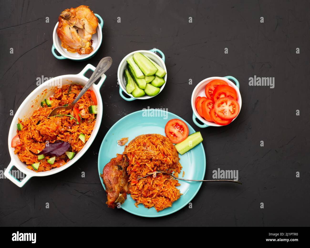 Jollof rice with chicken meat on a plate. Rice with tomatoes, onions ...