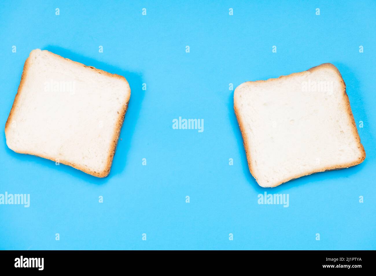 Two pieces of white toast on a blue background. Food concept Stock ...