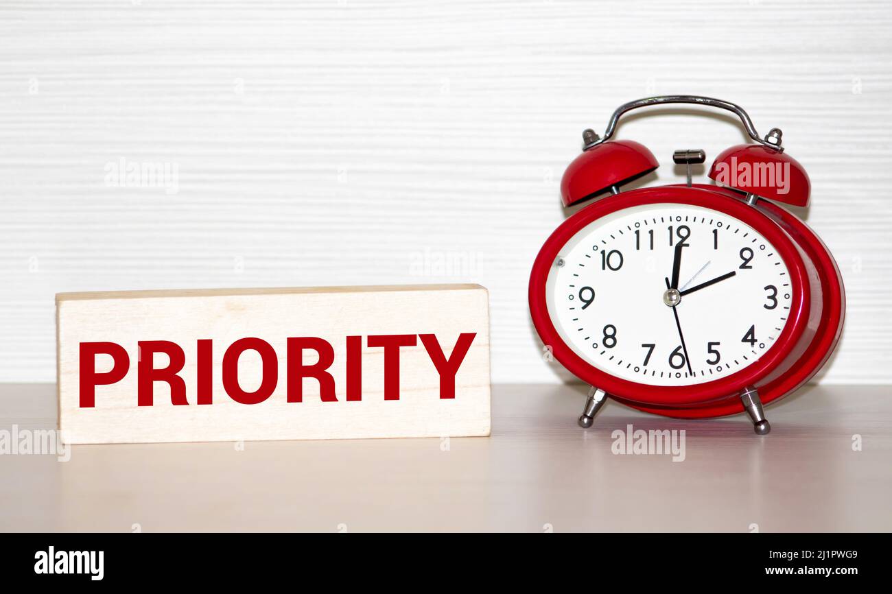 priority word handwritten on chalkboard with vintage precise stopwatch ...