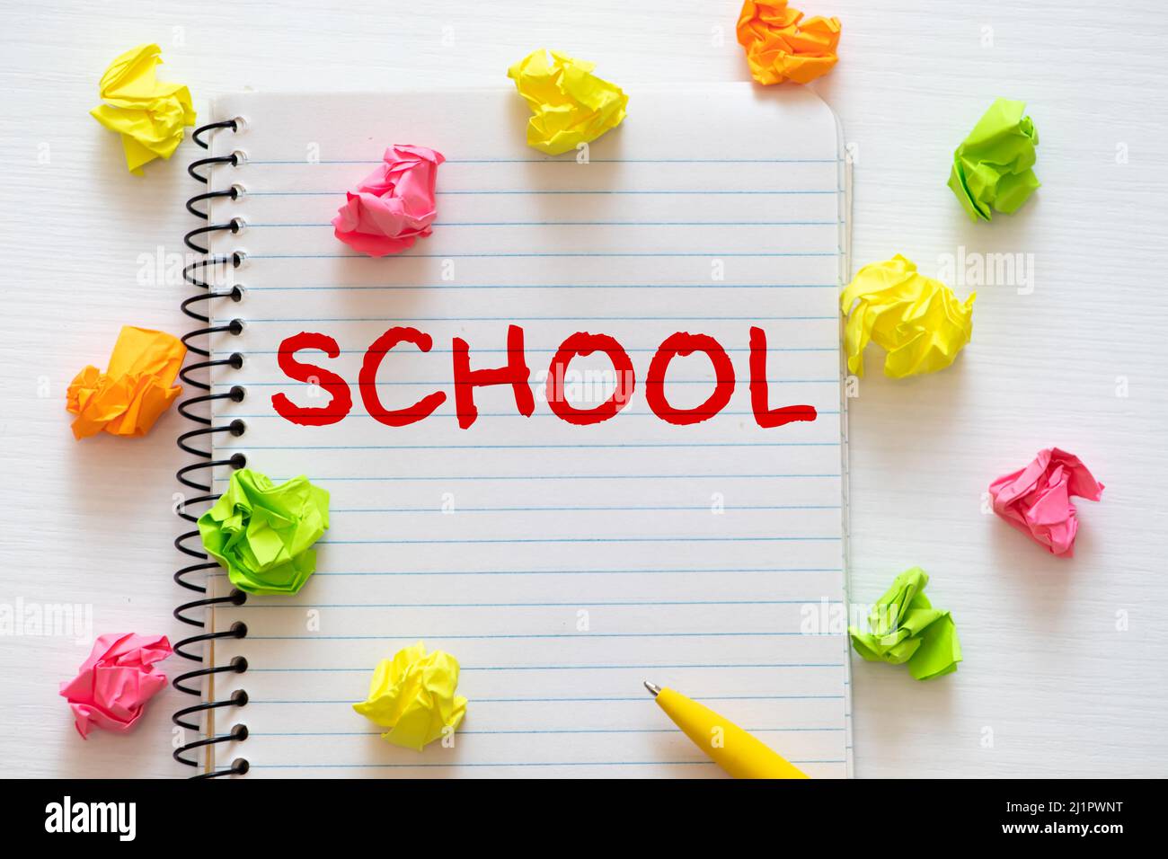 The word school on small pieces of paper on a blue background .The ...