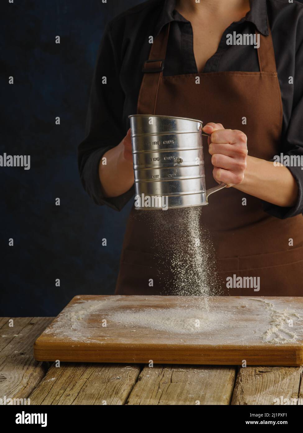 The process of preparing dough with the chef's hands on a dark ...