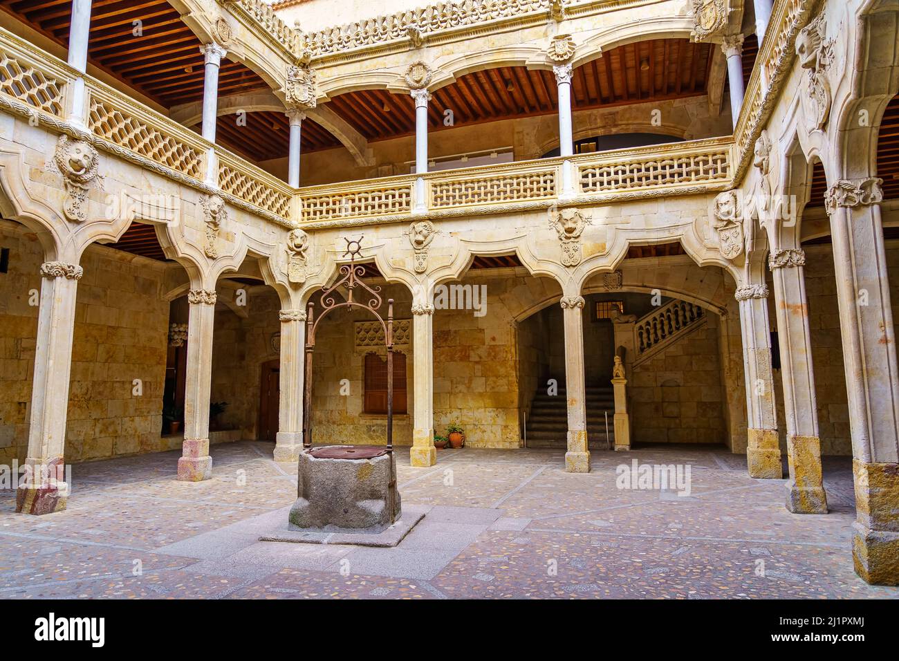 Medieval courtyard with stone arches and well in the center of the ...
