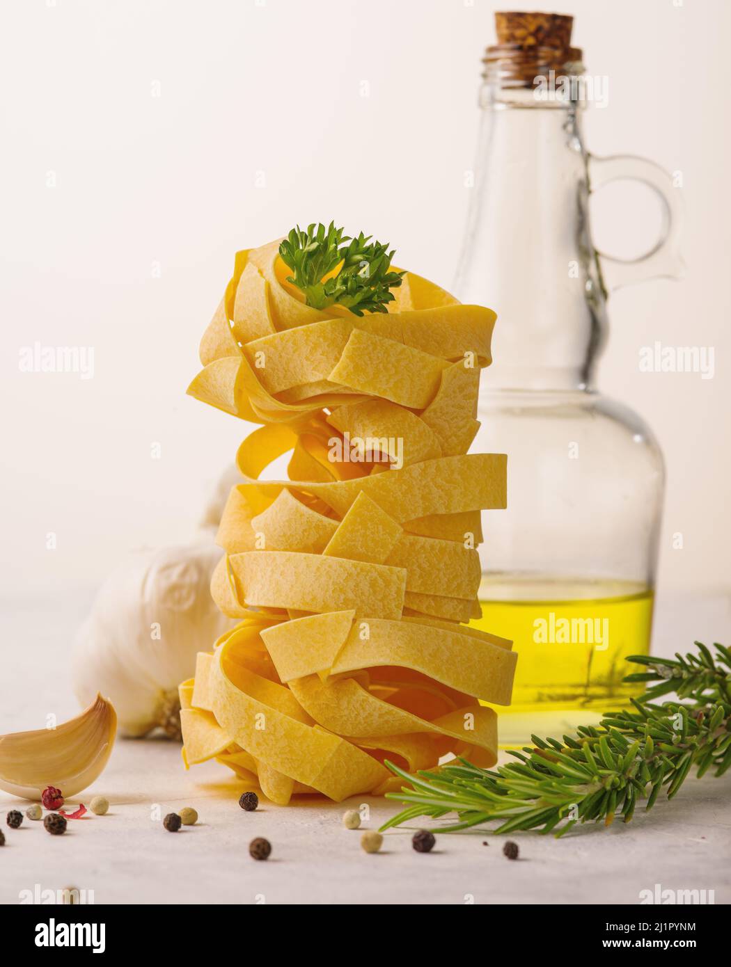 Italian pasta in a vertical serving, garlic, olive oil and a sprig of ...