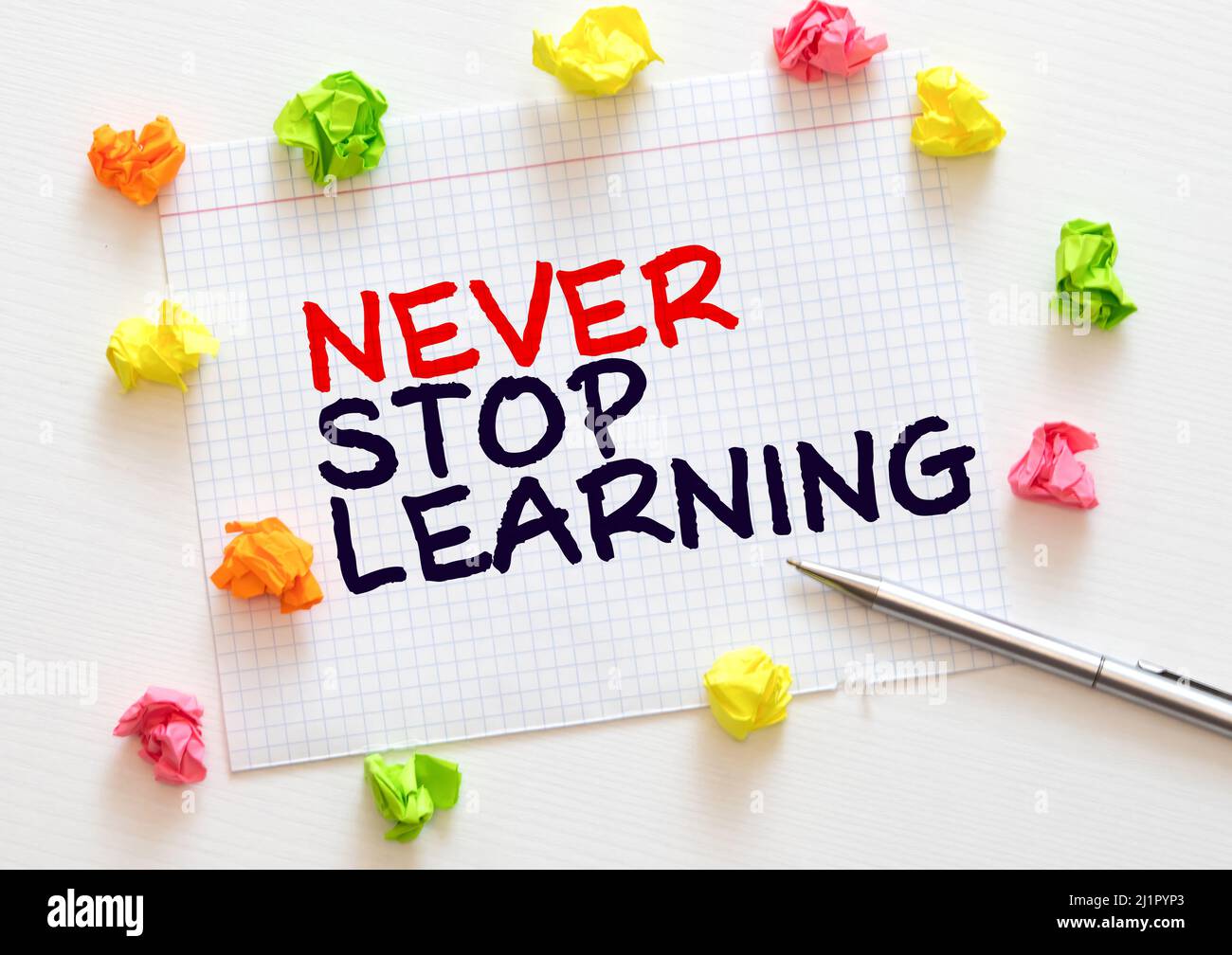 Never Stop Learning, handwriting quotation on notebook on white desk ...