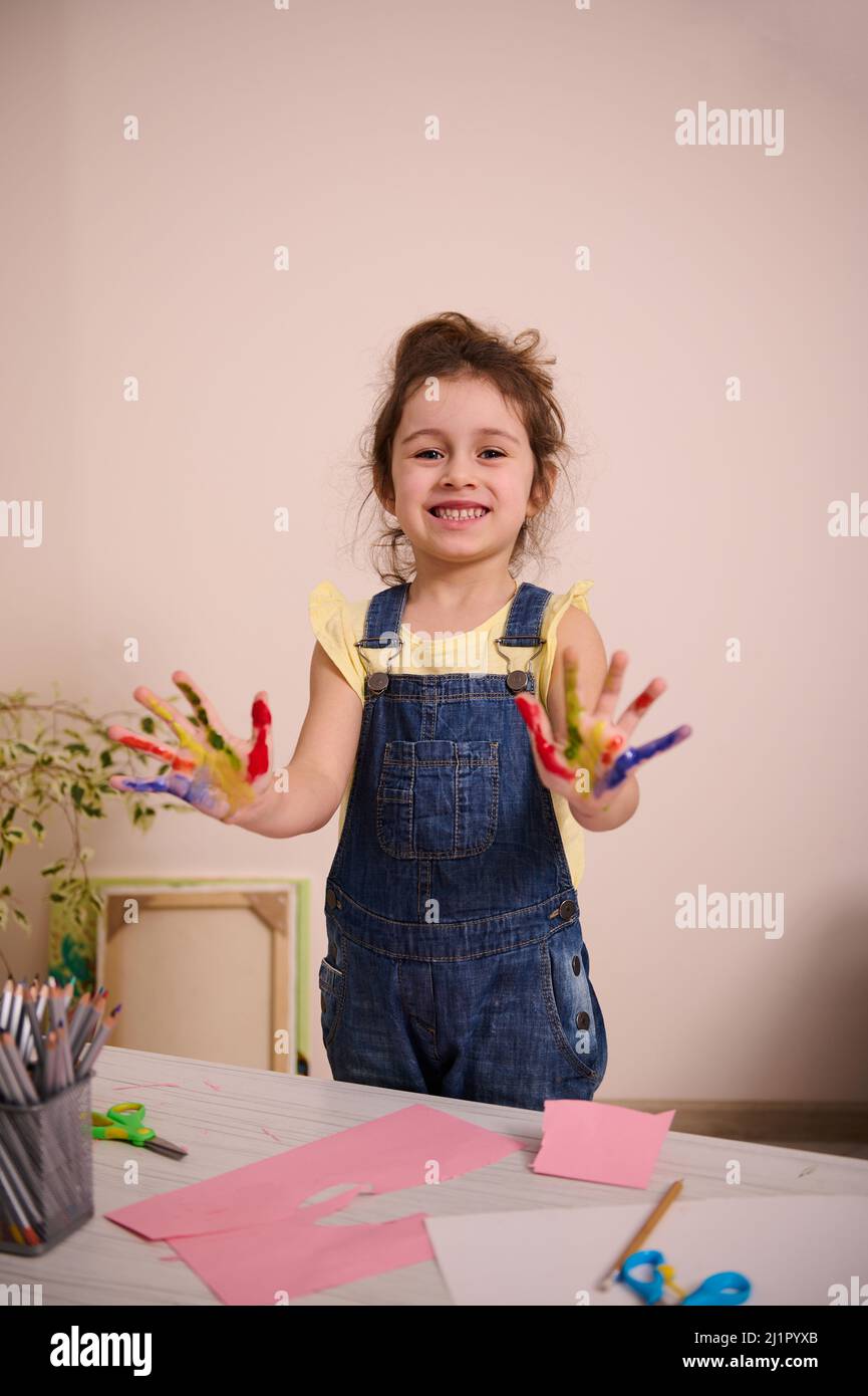 A charming Caucasian child, cute 4 years old girl smiles sweetly ...