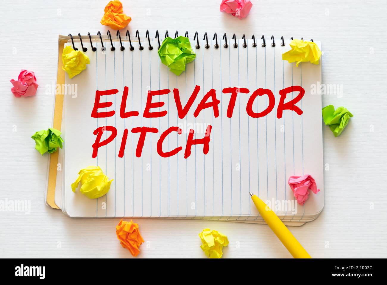 elevator pitch text message on white paper and office supplies, pen ...