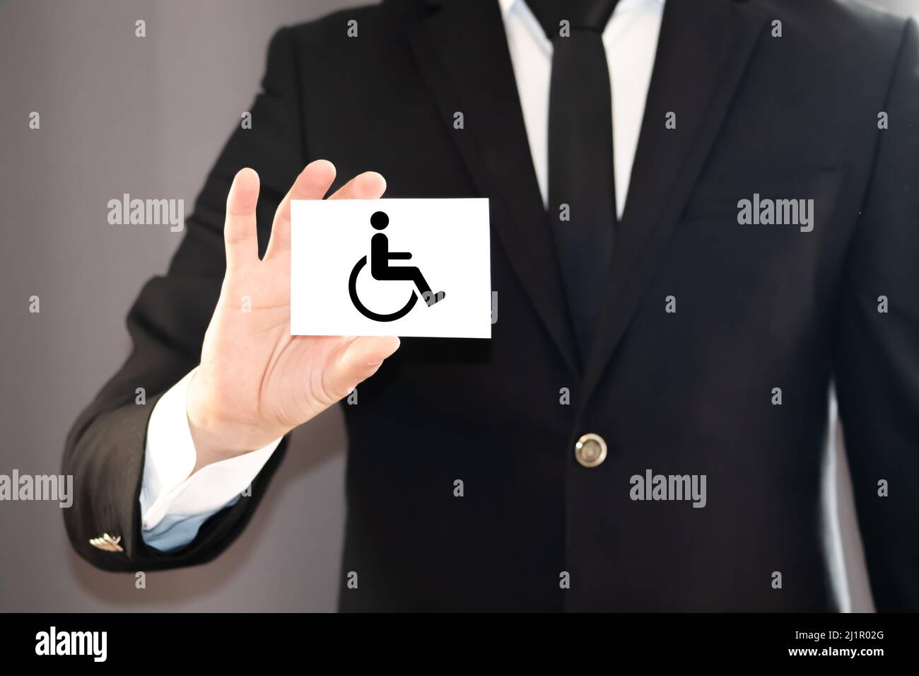 Hands Holding Paper With Cutout Disabled Sign Outdoors Stock Photo - Alamy