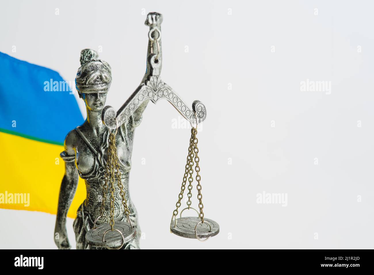 Goddess of justice Themis and the state flag of Ukraine on a white ...