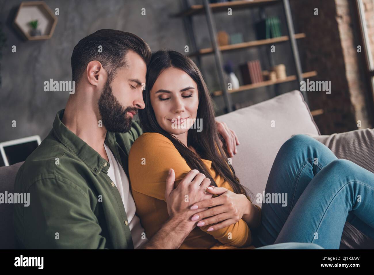Cute couple cuddling on couch hi-res stock photography and images - Alamy