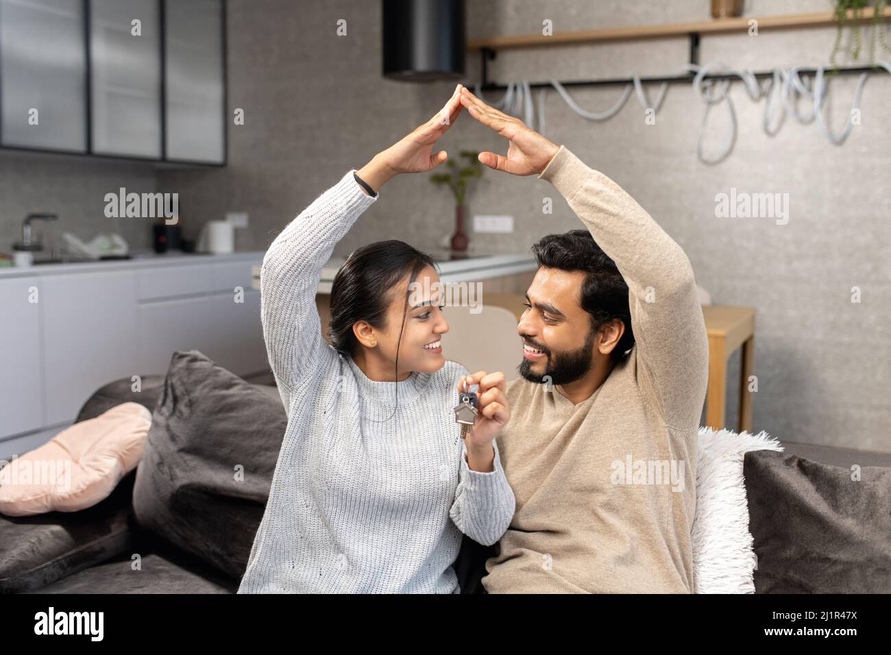 Happy Indian family couple showing new house keys to camera while ...