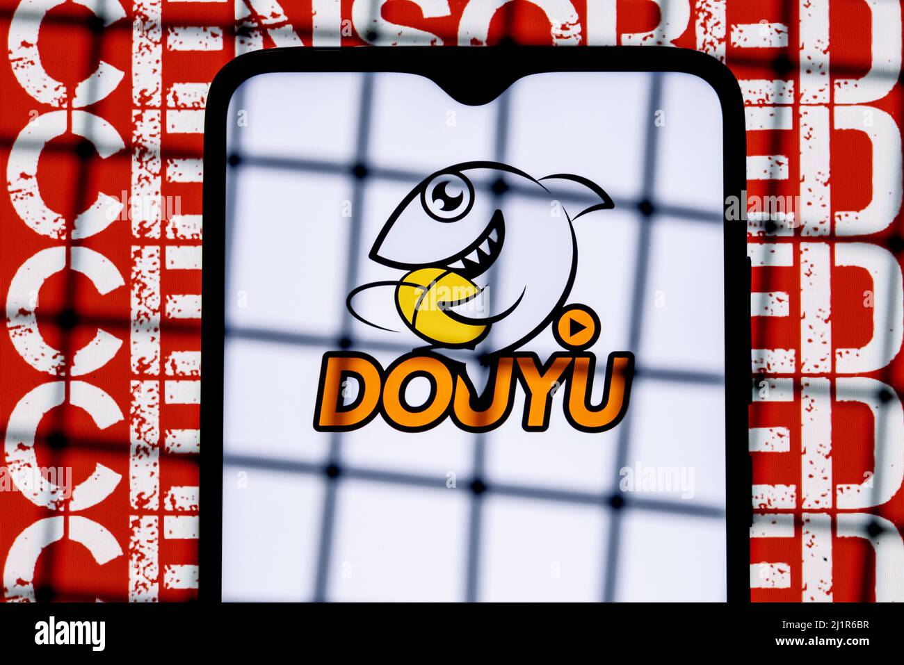 DouYu live streaming service logo on the smartphone screen behind the ...