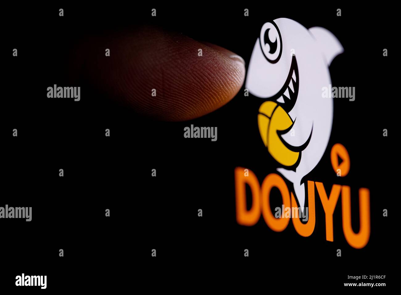 The finger reaches for the DouYu live streaming service logo on the ...