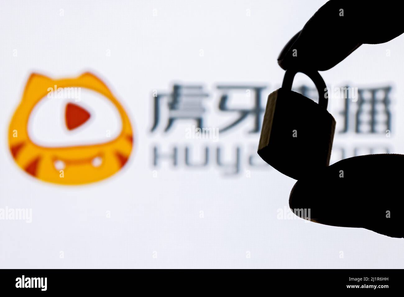 Fingers hold a closed security lock on the background of the Huya live ...