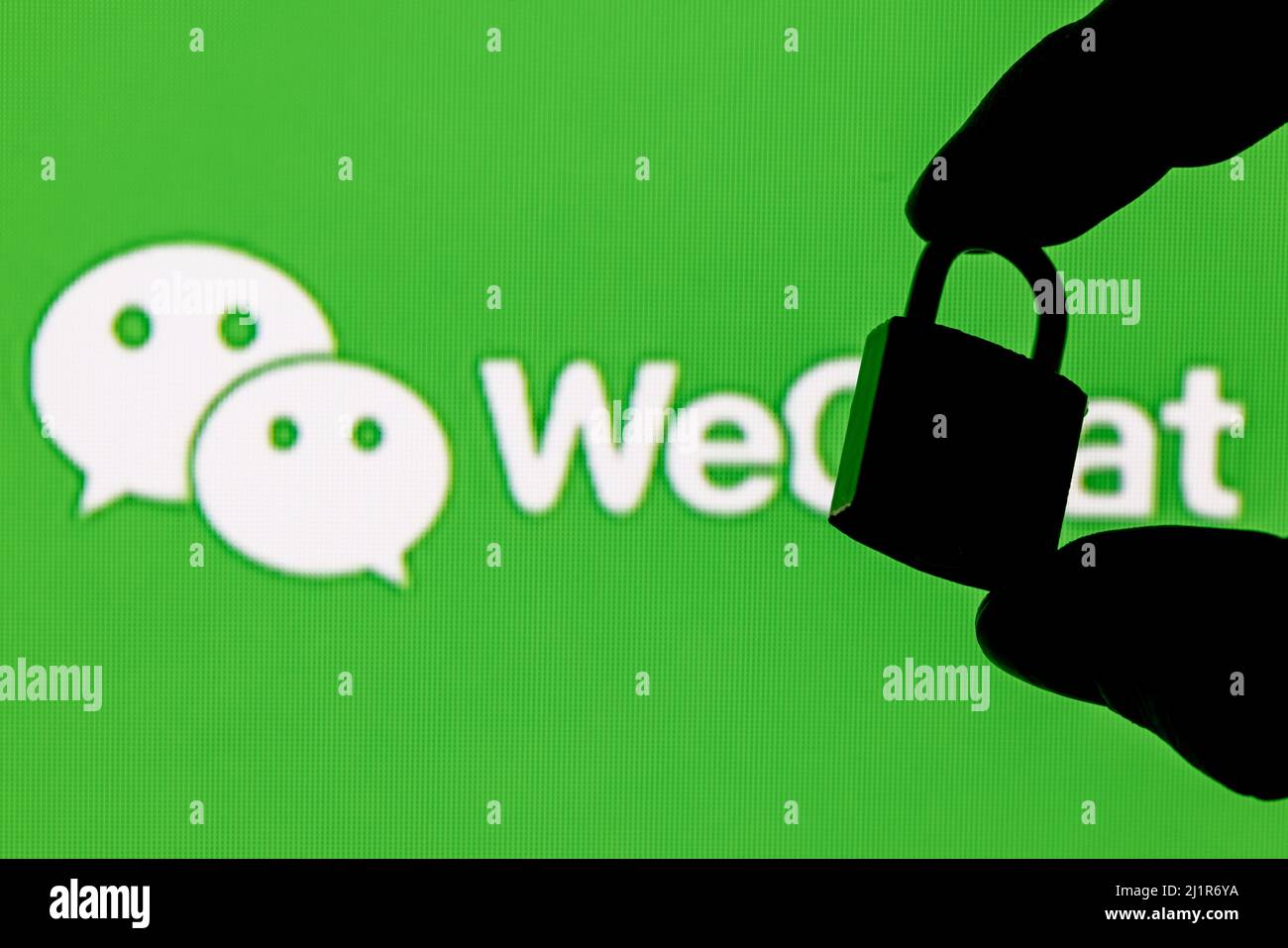 Fingers hold a closed security lock on the background of the WeChat ...