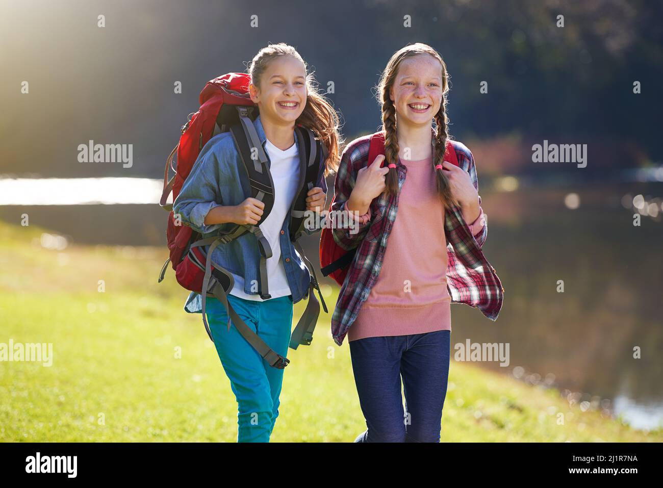 On a girls adventure. Shot of two young girls wearing backpacks walking ...