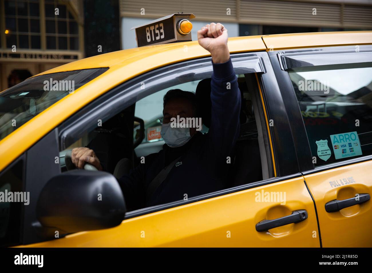 New York City, United States. 27th Mar, 2022. A taxi driver raises his ...