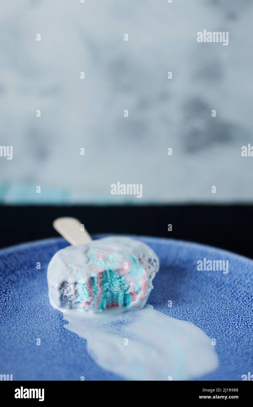 bitten vanilla ice cream on a blue plate. frosty milk sweetness Stock ...