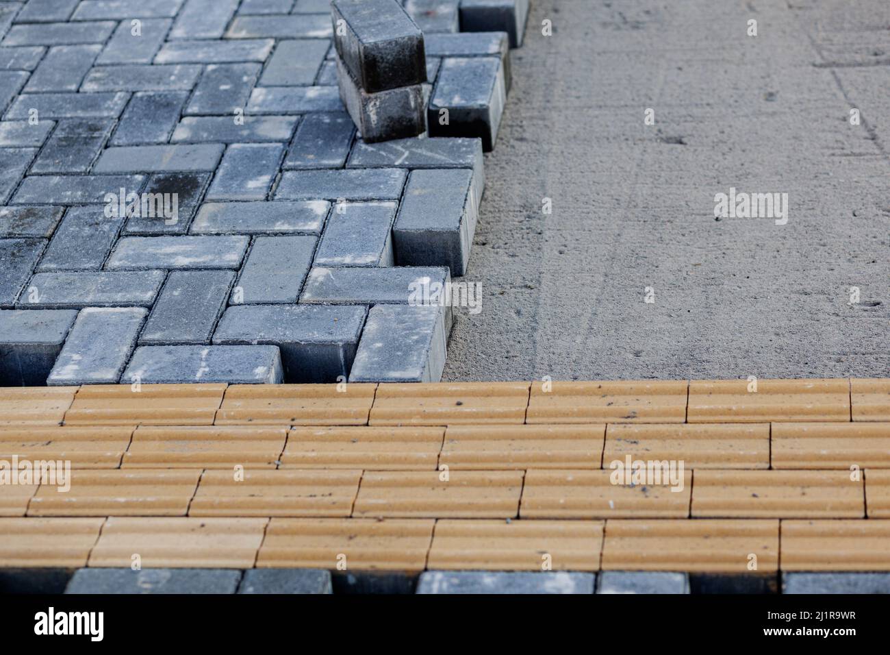 road is paved with concrete paving stones. laying paving slabs Stock ...