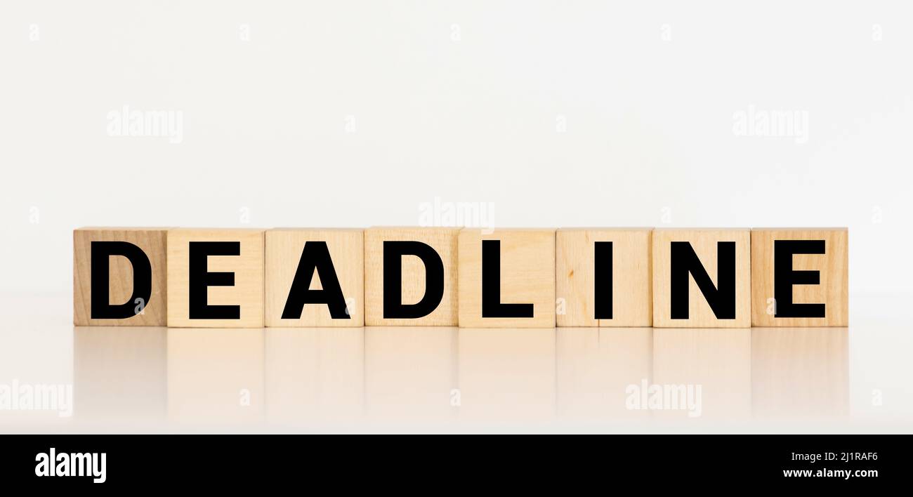 DEADLINE word written on wood block. DEADLINE text on wooden table for ...