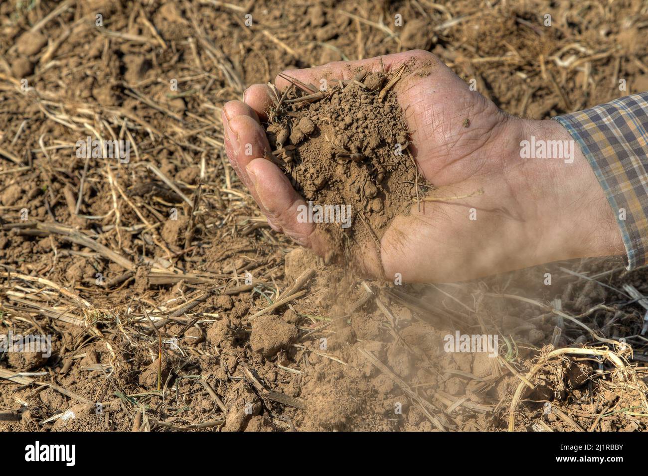 A farmer examines his dry, dusty soil in his hand. Already in March it ...