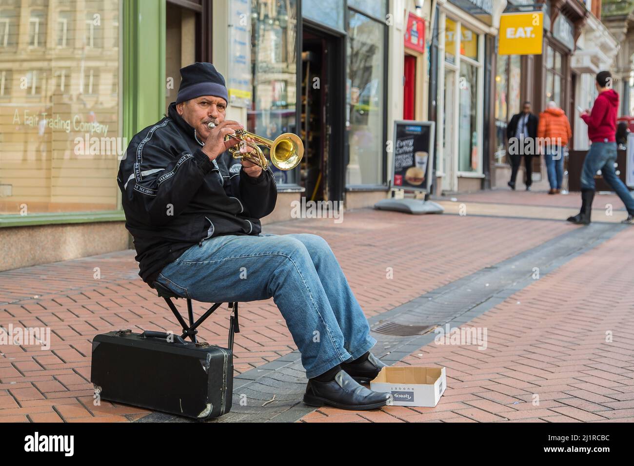 A busker playing a trumpet in a city centre Stock Photo - Alamy