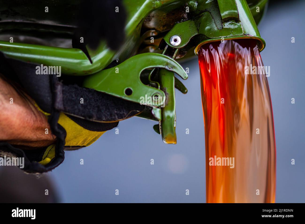 Pouring a stready stream of red fuel Stock Photo - Alamy