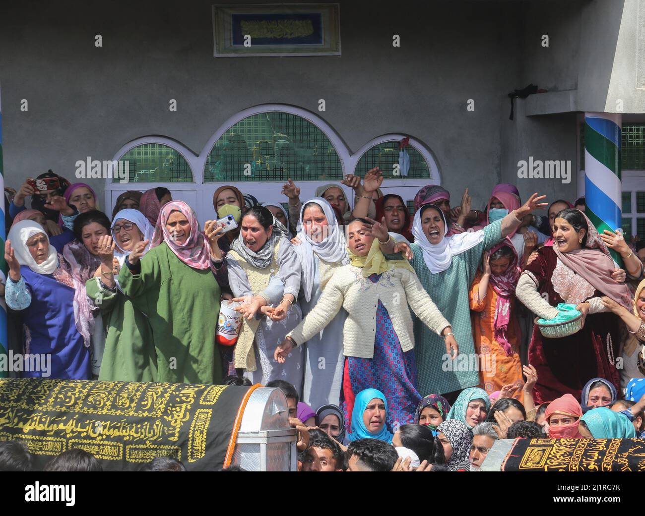Relatives and neighbours mourn as people carry the coffins of slain Indian policeman Ishfaq ...