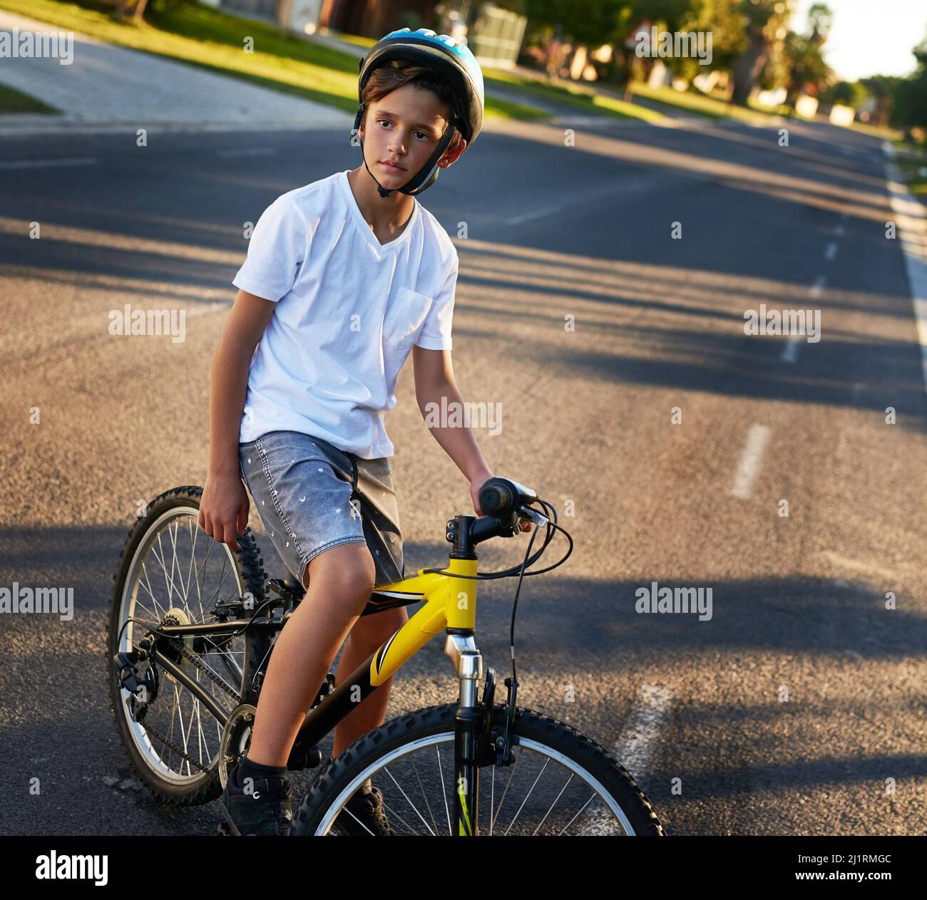 Cycling through his block. Shot of a young boy riding his bicycle ...