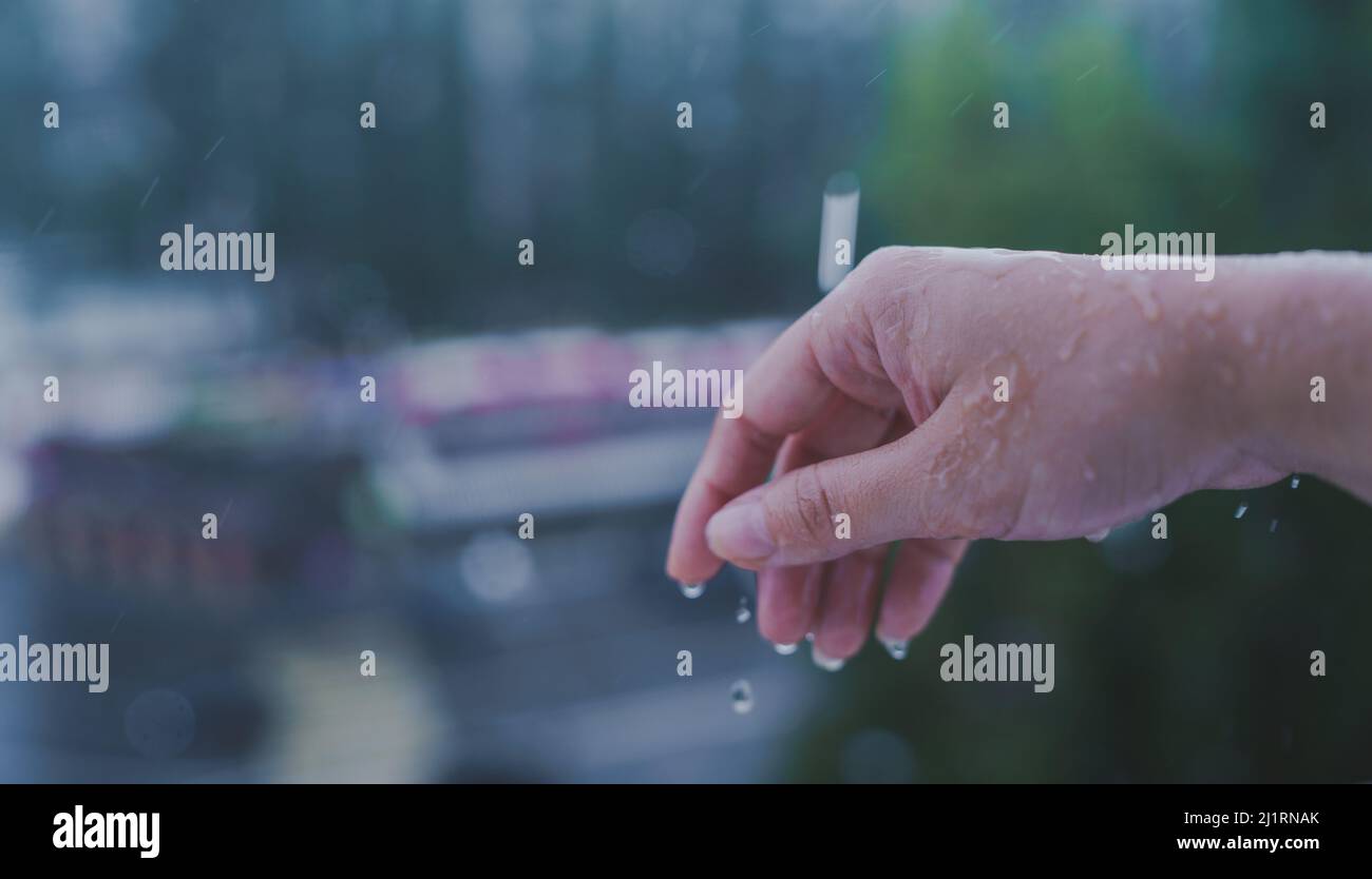Rainy weather, rain drops falling on womans hand Stock Photo - Alamy