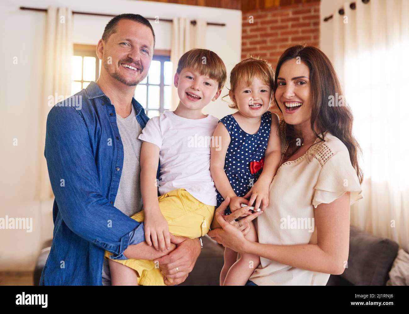 Our home, our happy place. Portrait of a happy young family spending quality time together at at ...