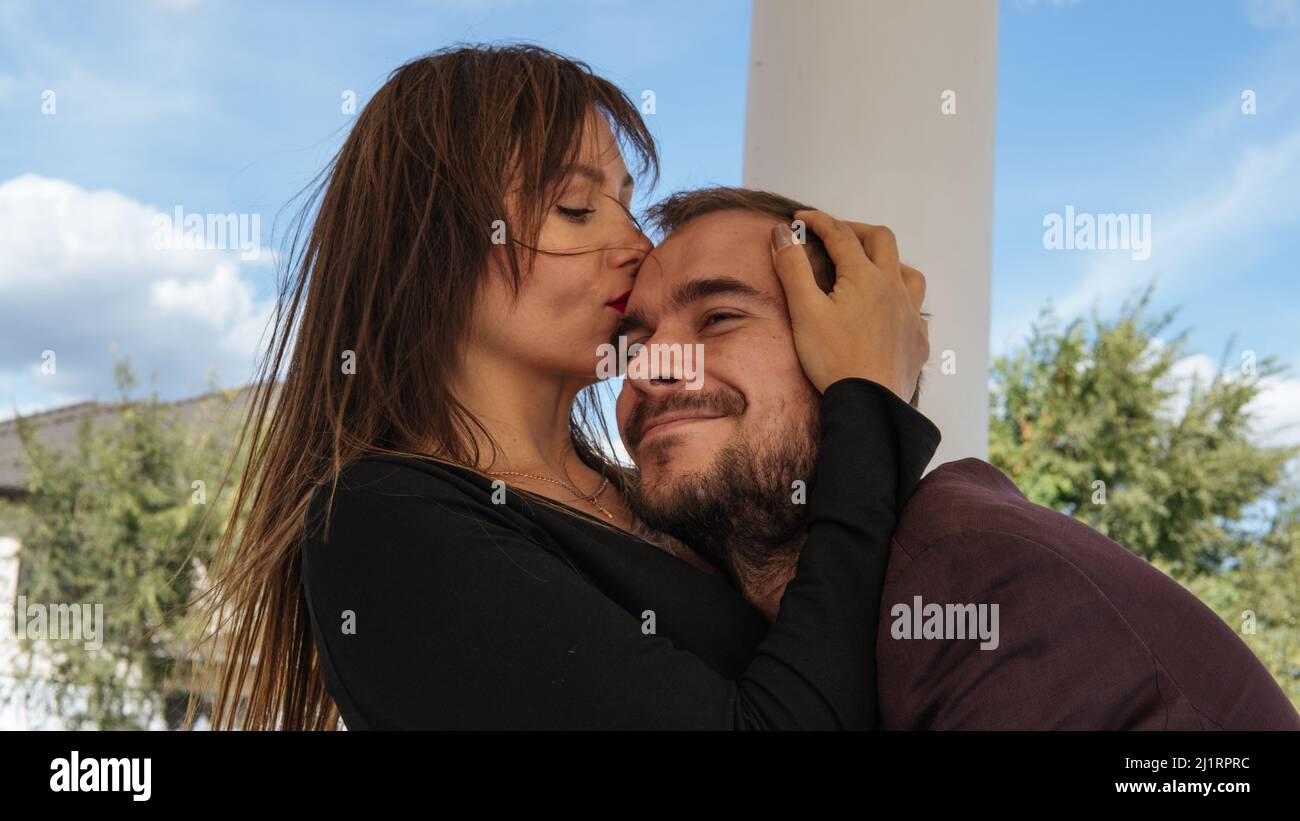 A young beautiful woman with long dark hair kisses Stock Photo - Alamy