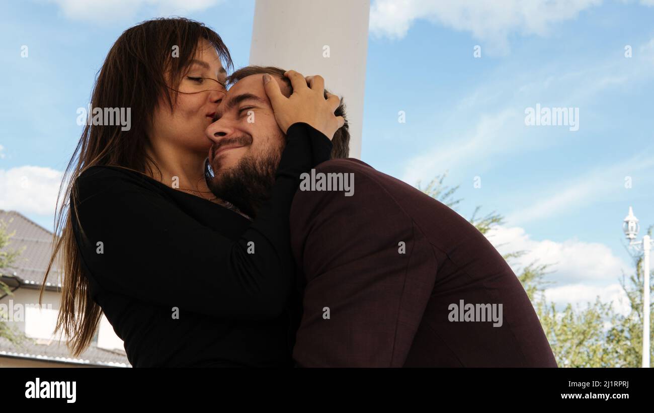 A young beautiful woman with long dark hair kisses Stock Photo - Alamy