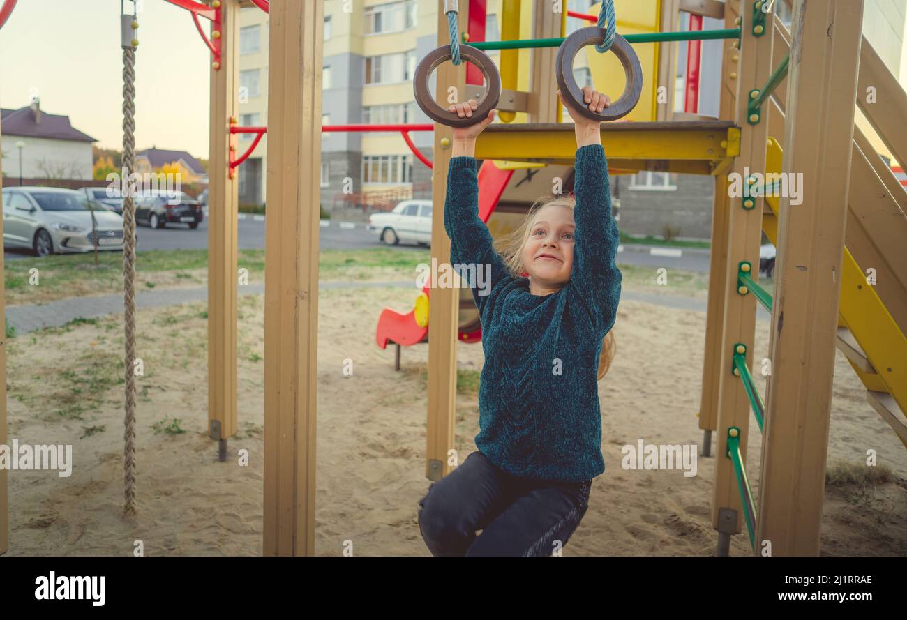 child play and frolic on the Playground. A girl in a blue sweater plays ...
