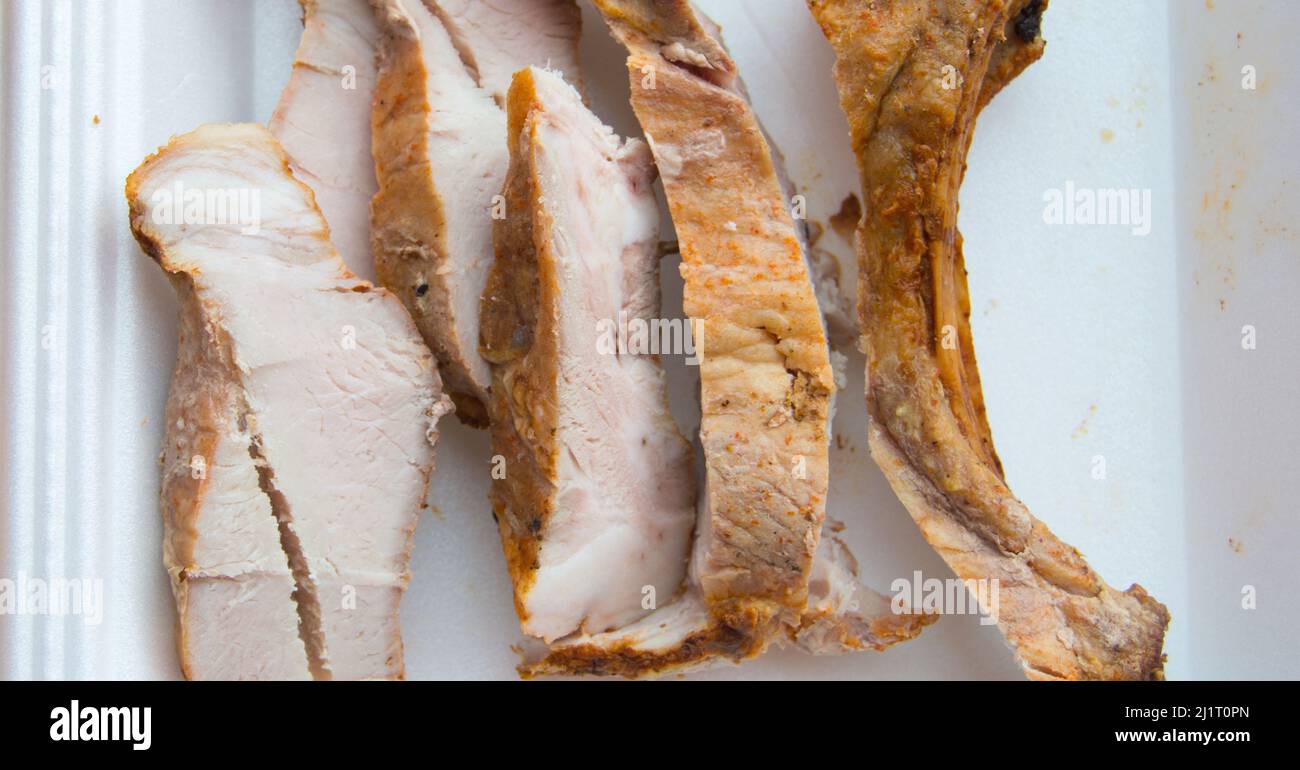Close-up of sliced pieces of cold baked pork in a plastic container ...