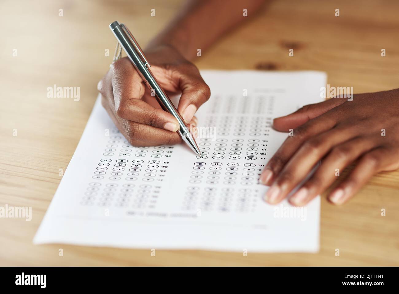 Taking a test. Shot of a person filling in an answer sheet for a test ...