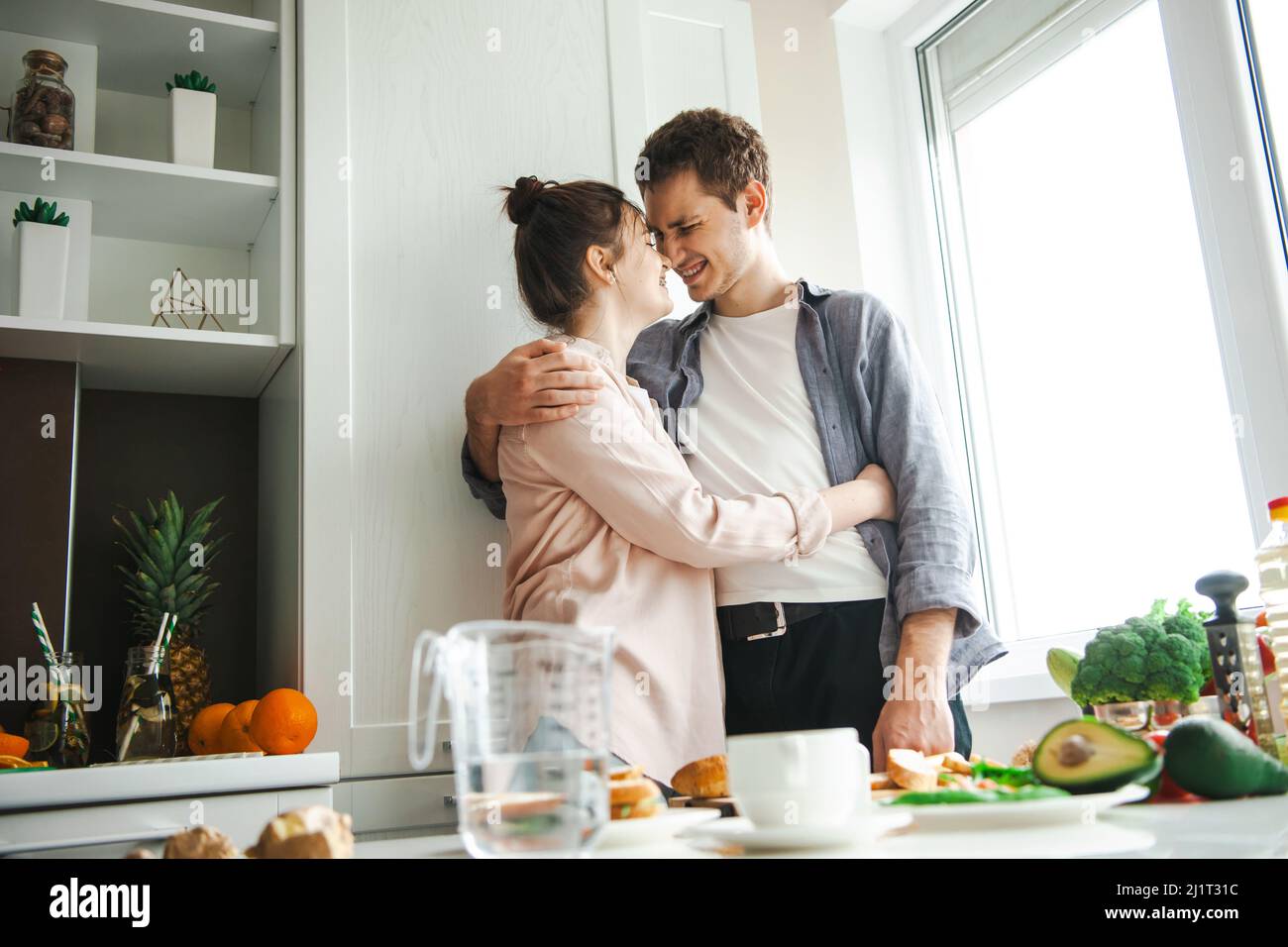 Couple hugging while standing in the kitchen wanting to make breakfast ...