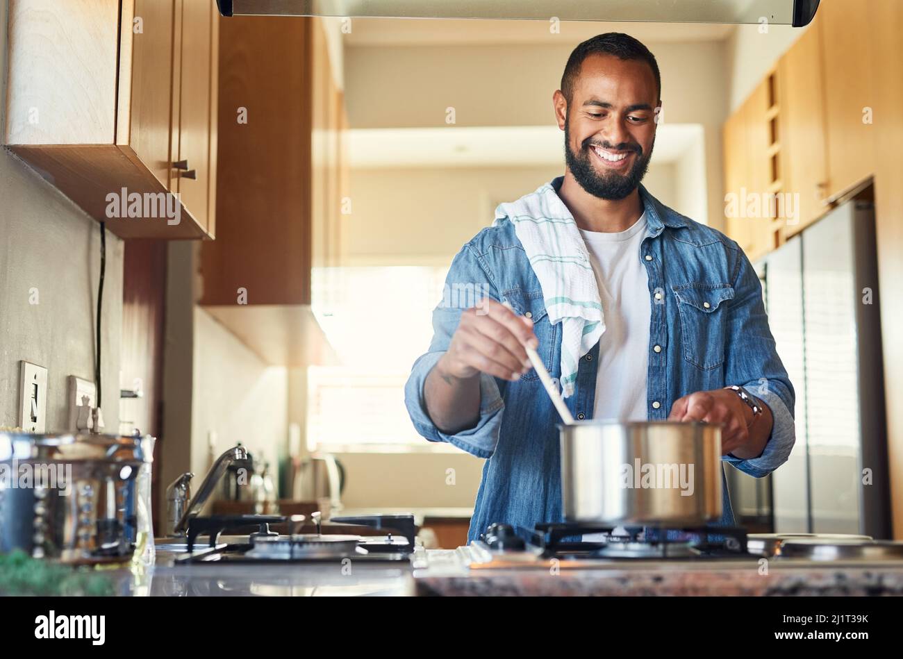 I cant wait until its done. Shot of a young man cooking at home Stock ...