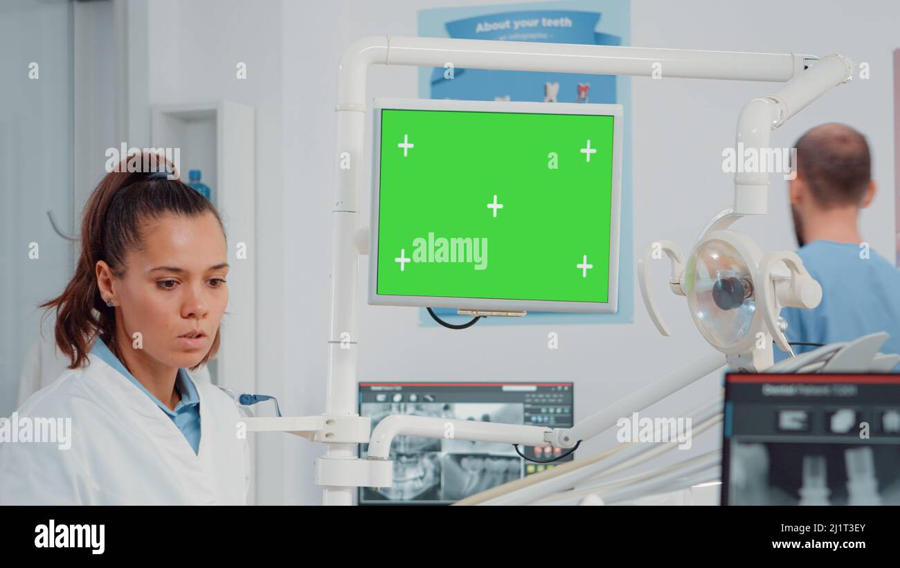 Close up of dentist looking at monitor with green screen for teeth scan ...