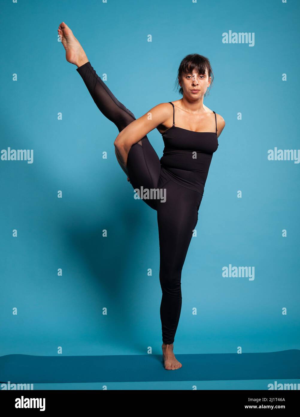 Active athletic woman practicing one leg up yoga pose training body ...