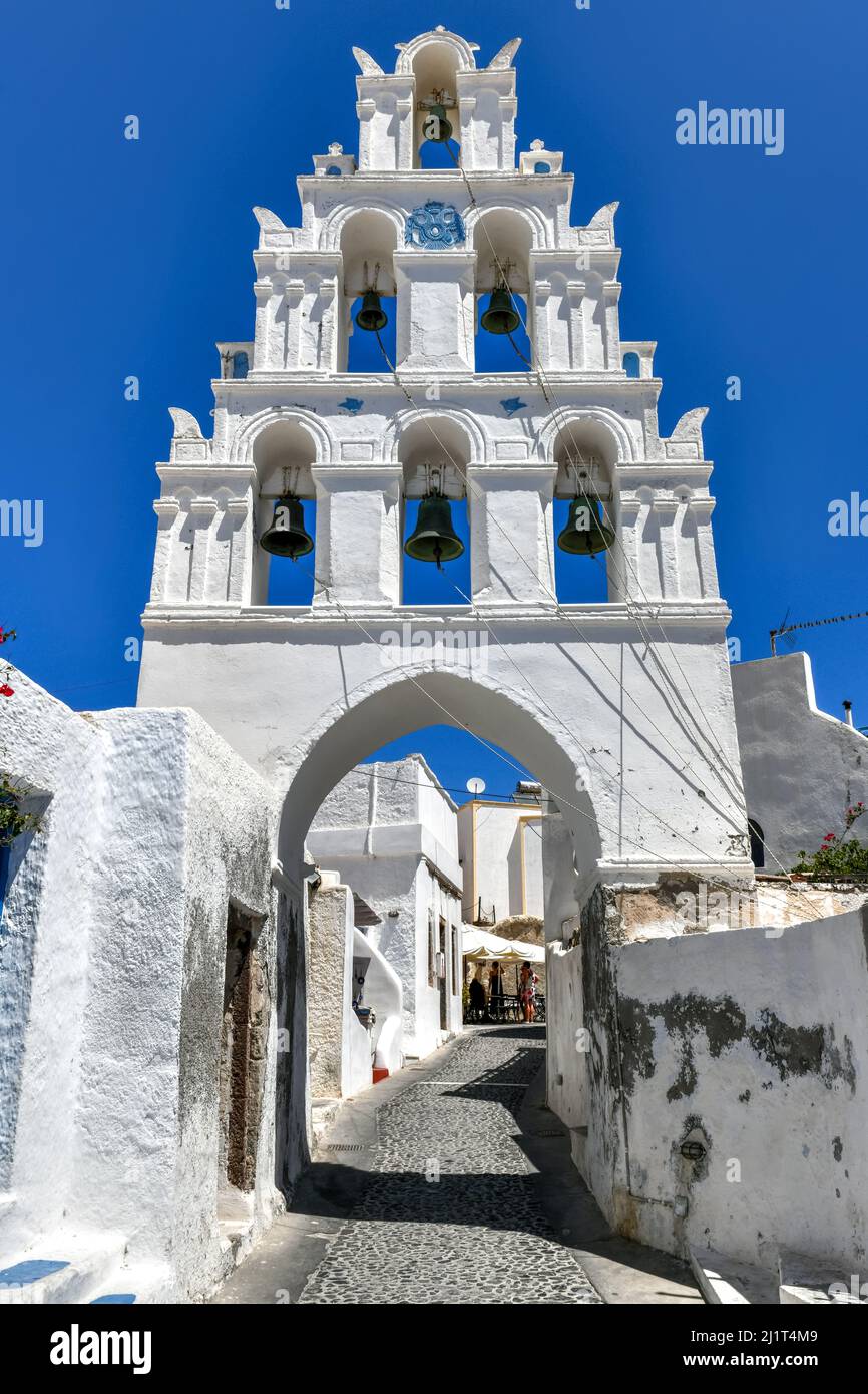A typical cobblestone street with an arched bell tower in the ...