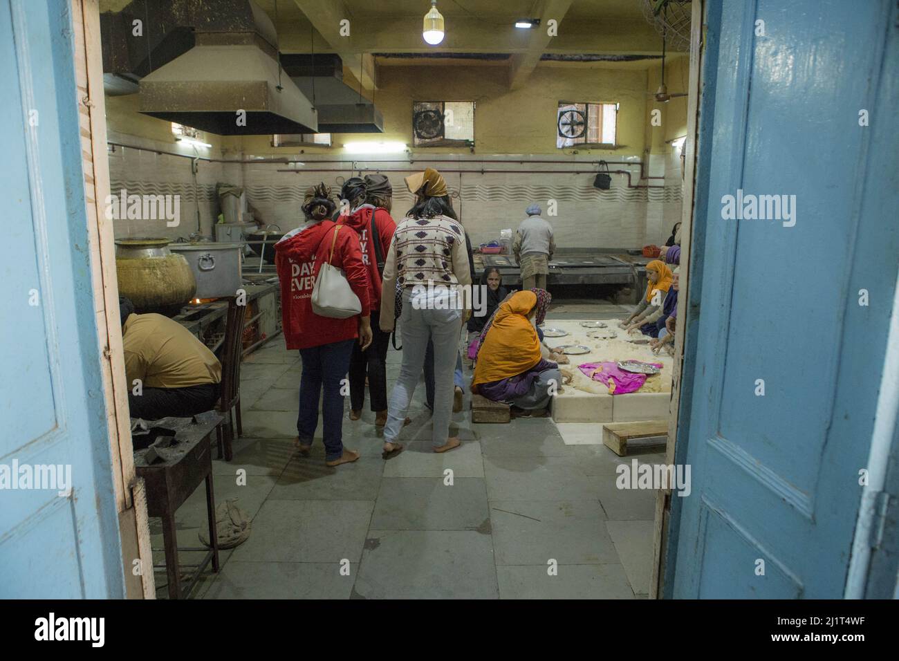 A group of locals and tourists at the free kitchen (Langar) of the ...