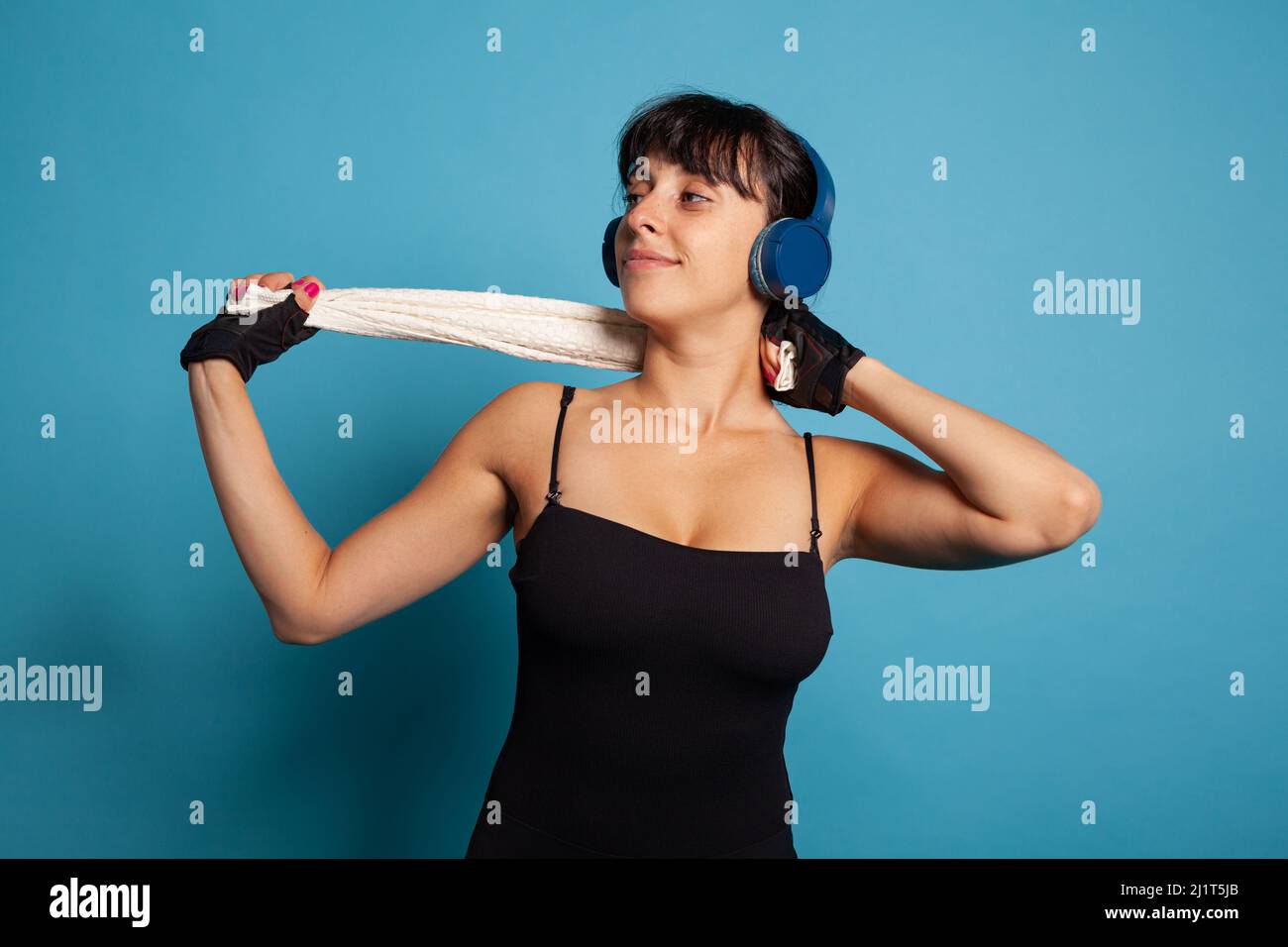 Strong personal trainer wearing headphone listening music while ...