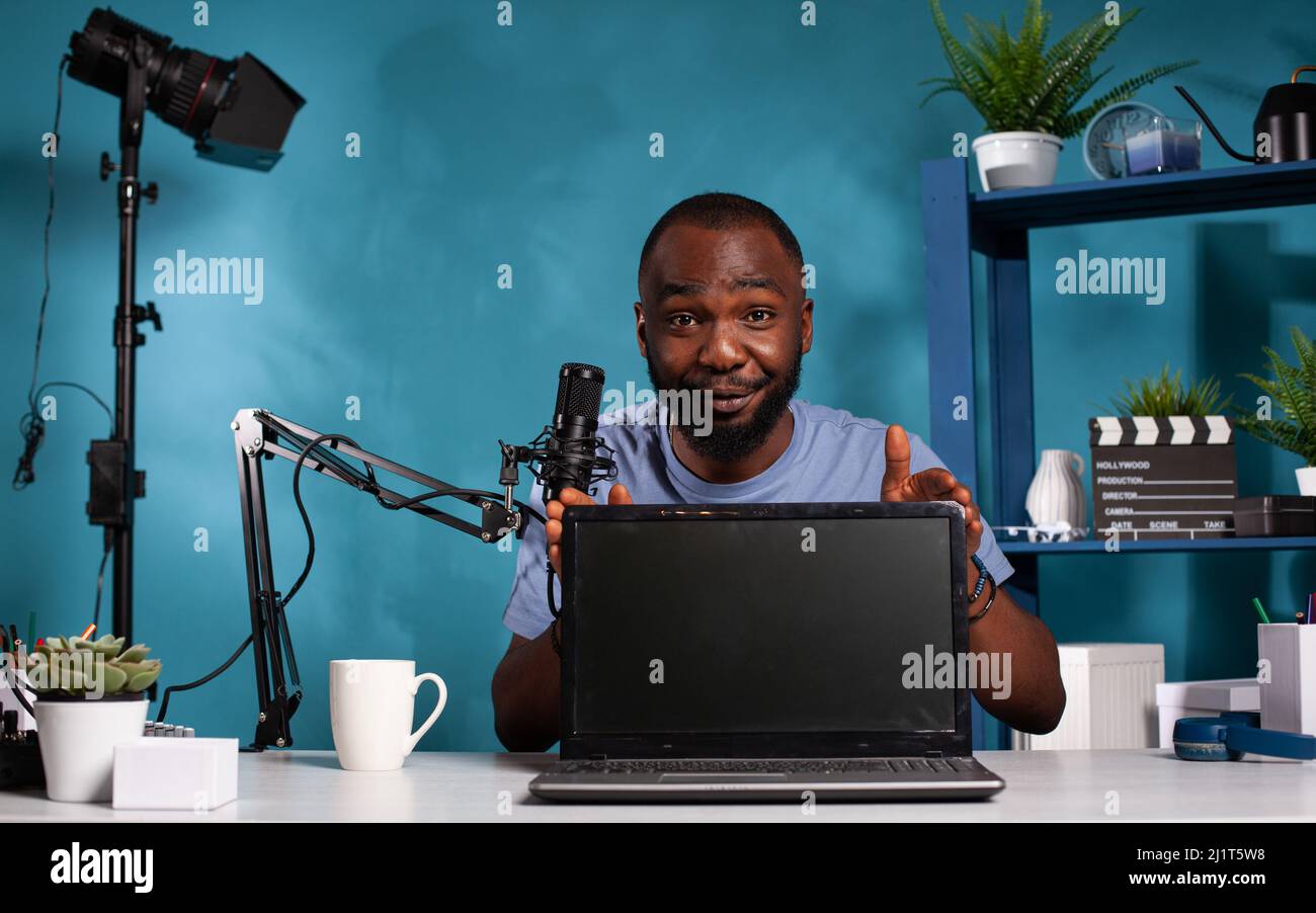 Portrait of reviewer showing new model laptop display technology on ...